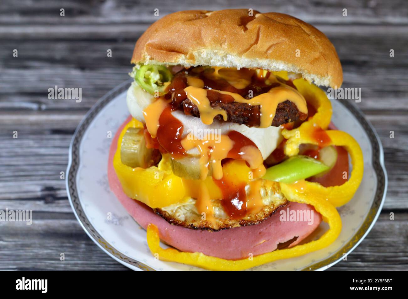 Fried beef burger with slices of pickled cucumbers, onions, luncheon ...