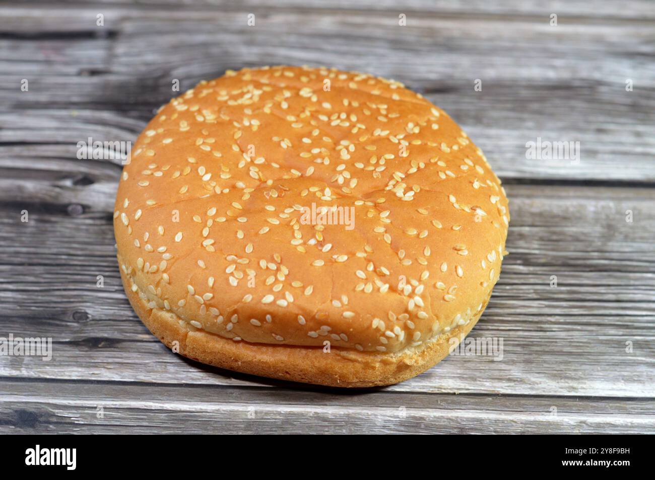 Round hand sized hamburger burger bun baked and covered with sesame ...
