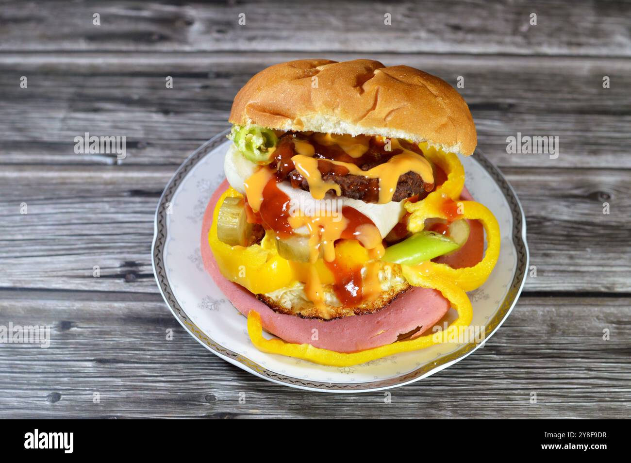 Fried beef burger with slices of pickled cucumbers, onions, luncheon ...