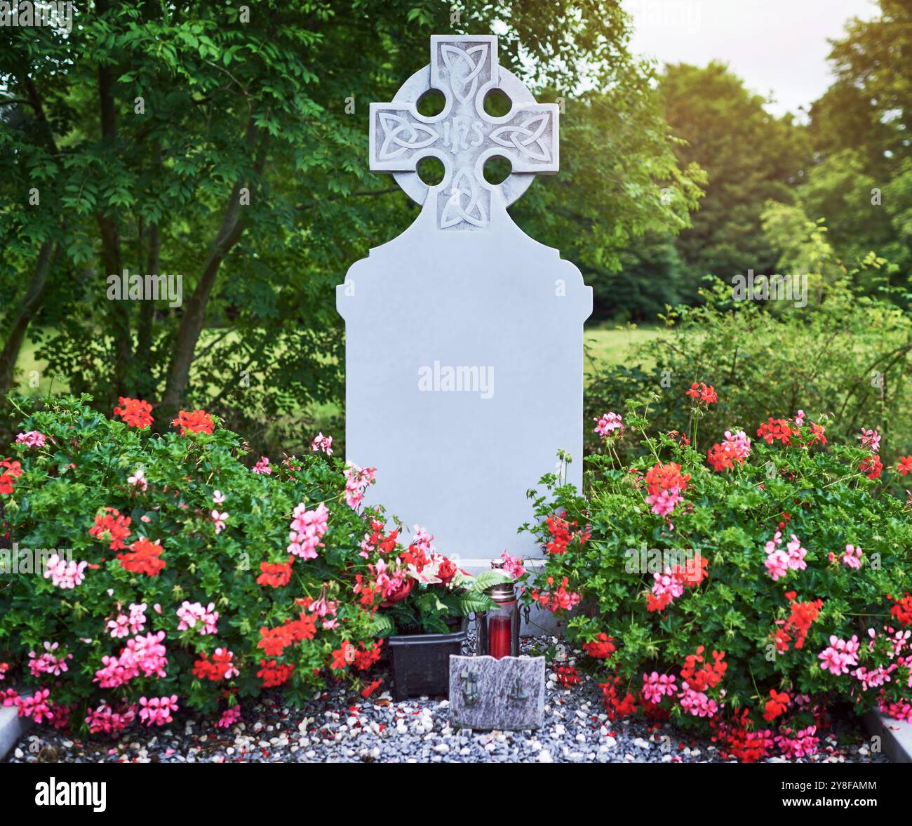 Celtic cross, tombstone and graveyard with flowers for memory, peace or mockup space outdoor ...