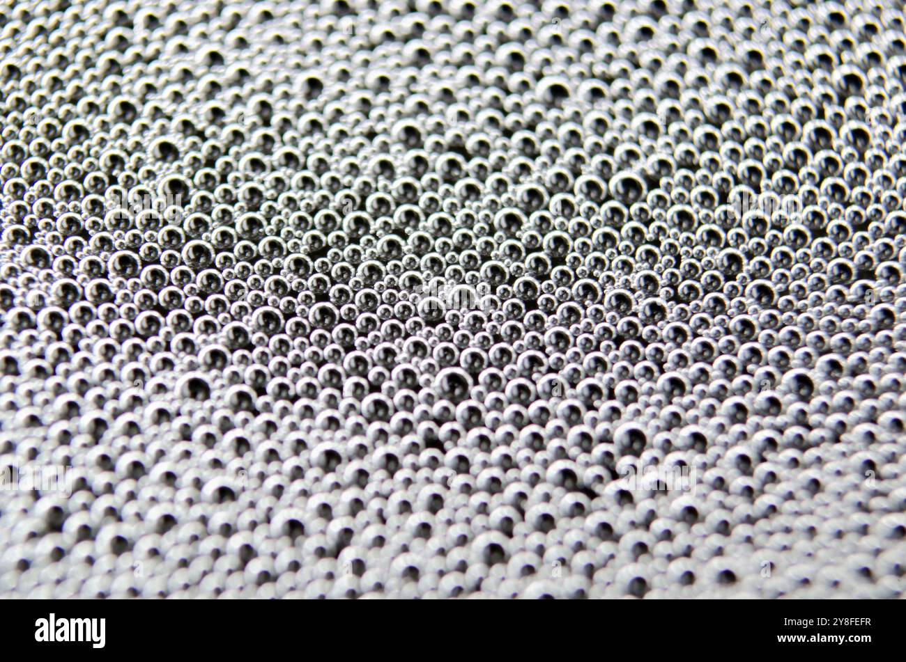 Top view of soap bubbles forming patterns on a textured surface ...