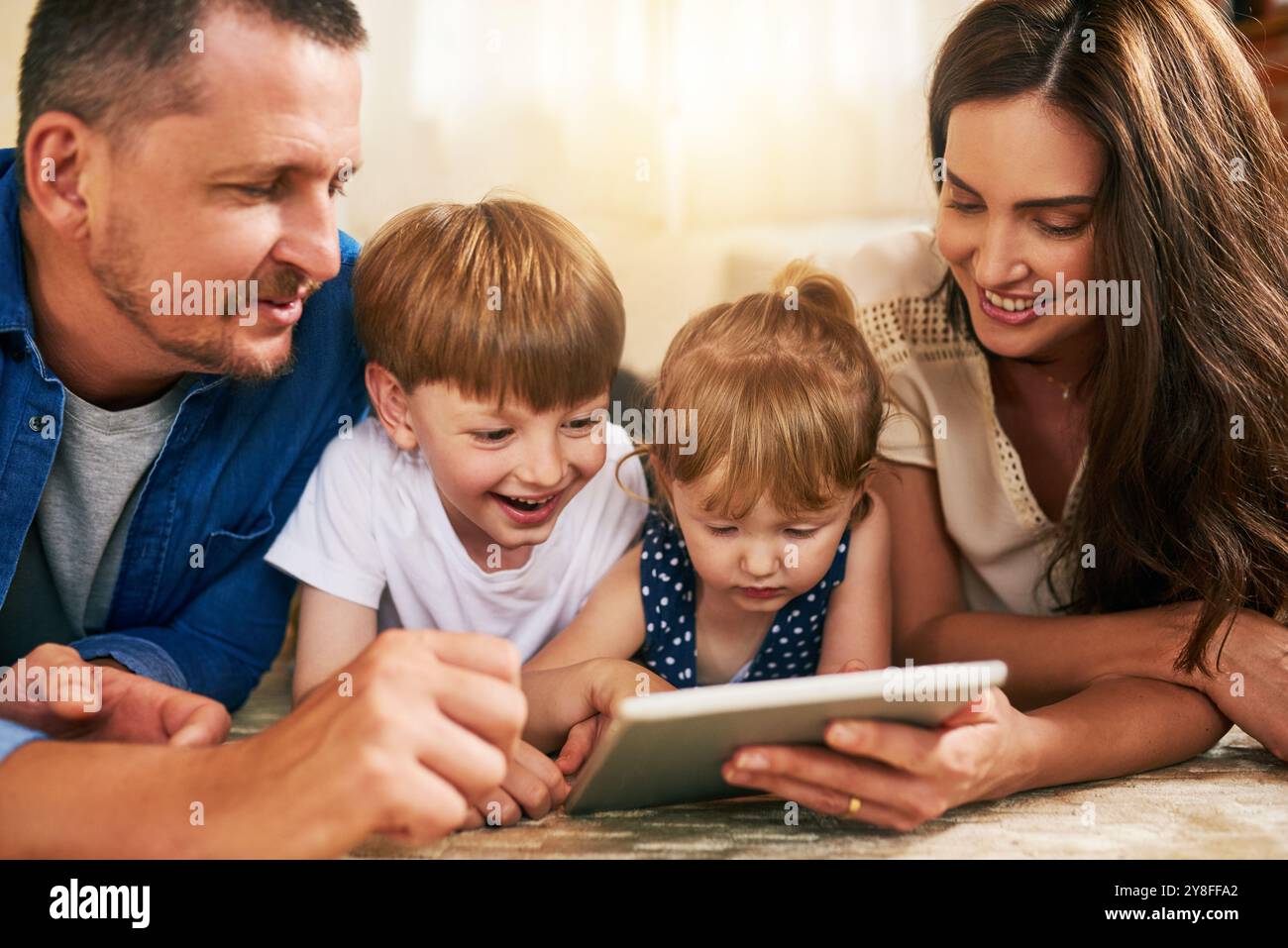 Parents, family and happy kids with tablet on floor for learning, education or reading funny ...