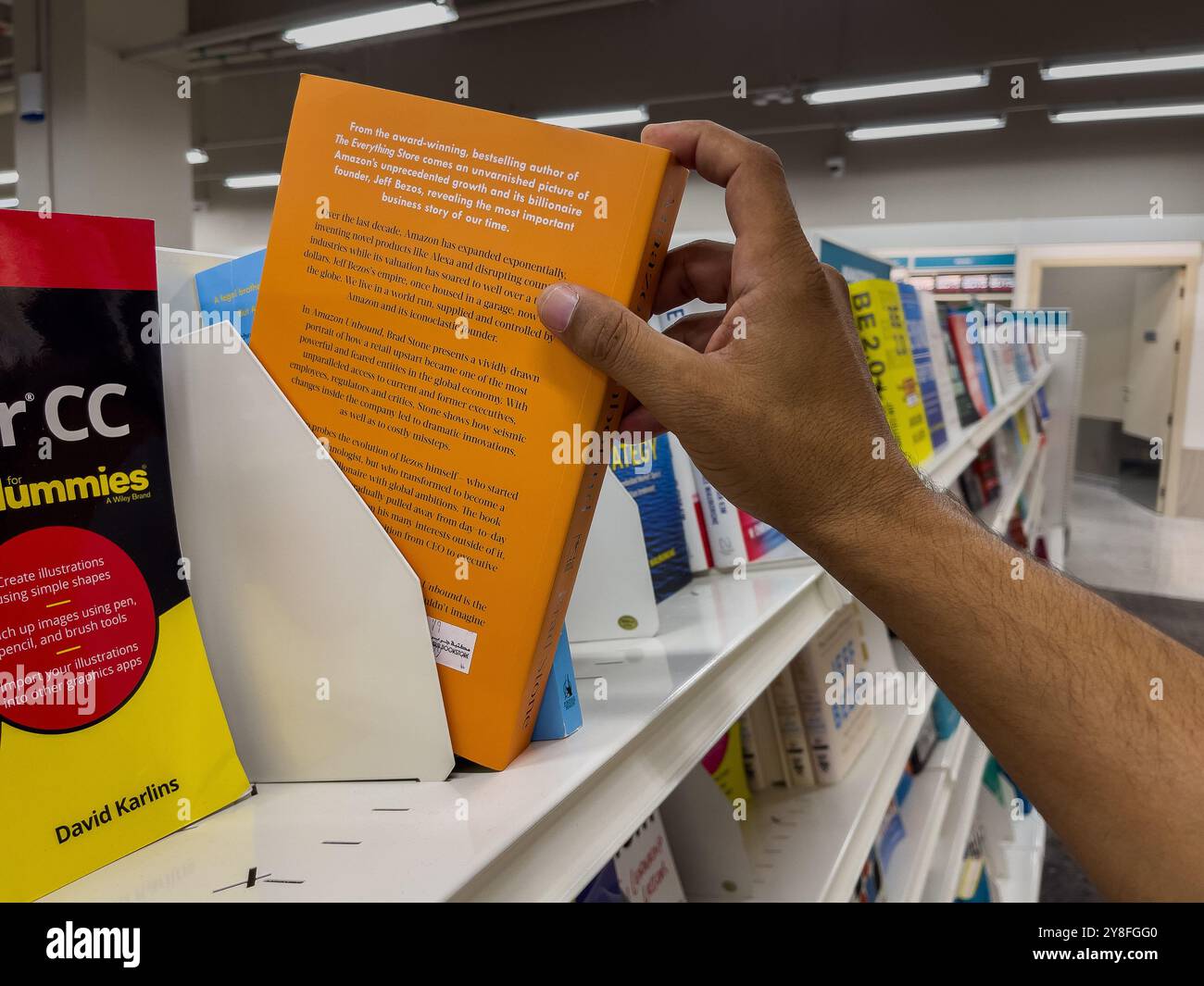 Man selecting a book from library bookshelf in Doha, Qatar Oct 05, 2024 ...