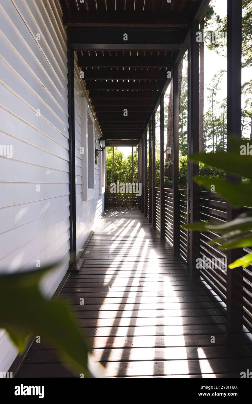 Wooden big empty house with corridor and barrier in big green garden ...