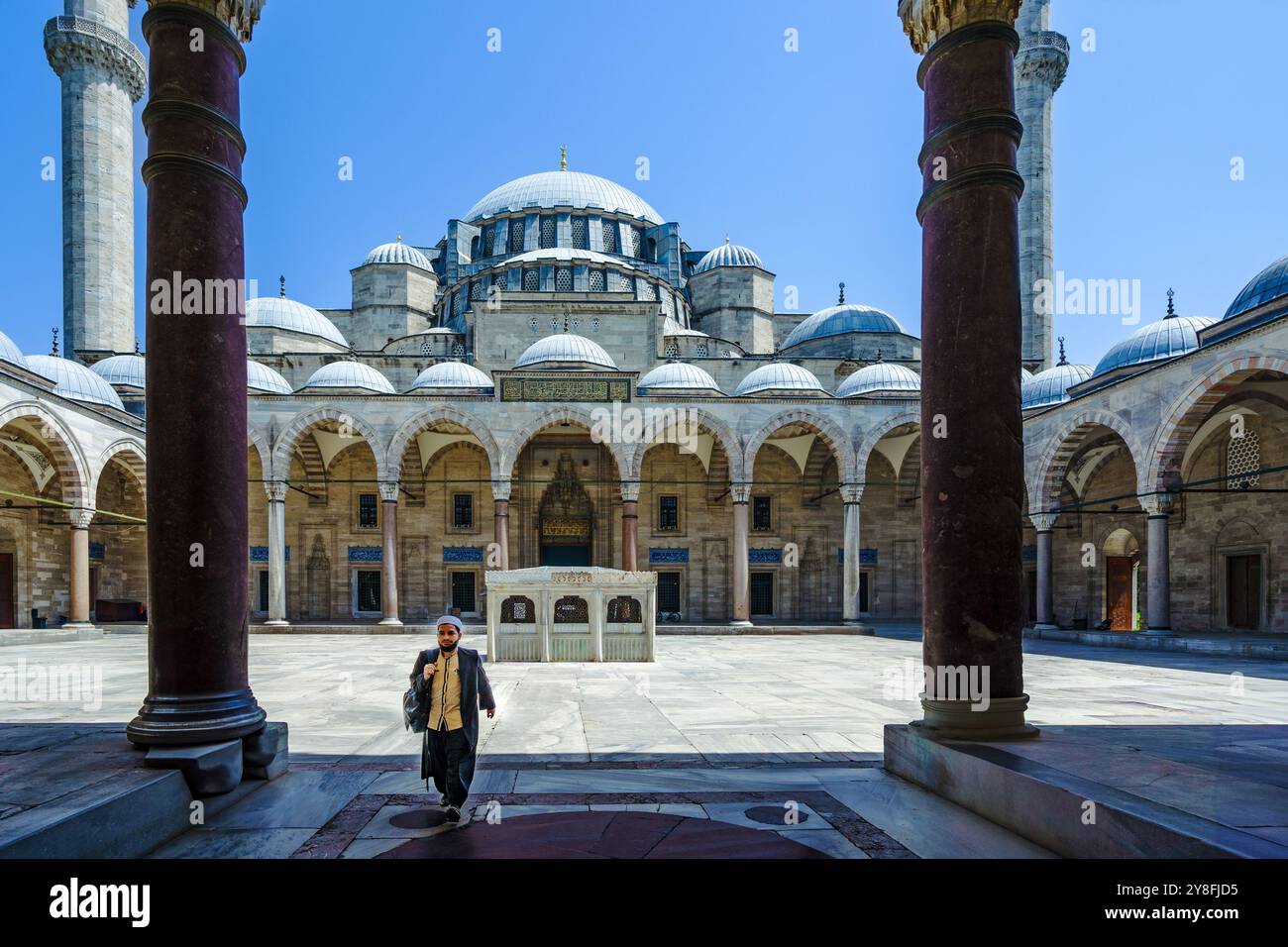 Turkiye. Istanbul. A Muslim man walks through the courtyard of the ...