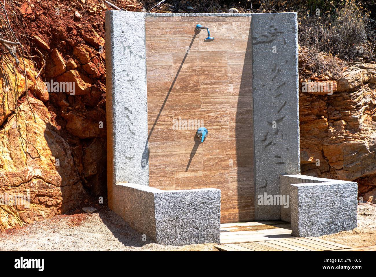 A refreshing beach shower set against a stone backdrop, blending modern ...