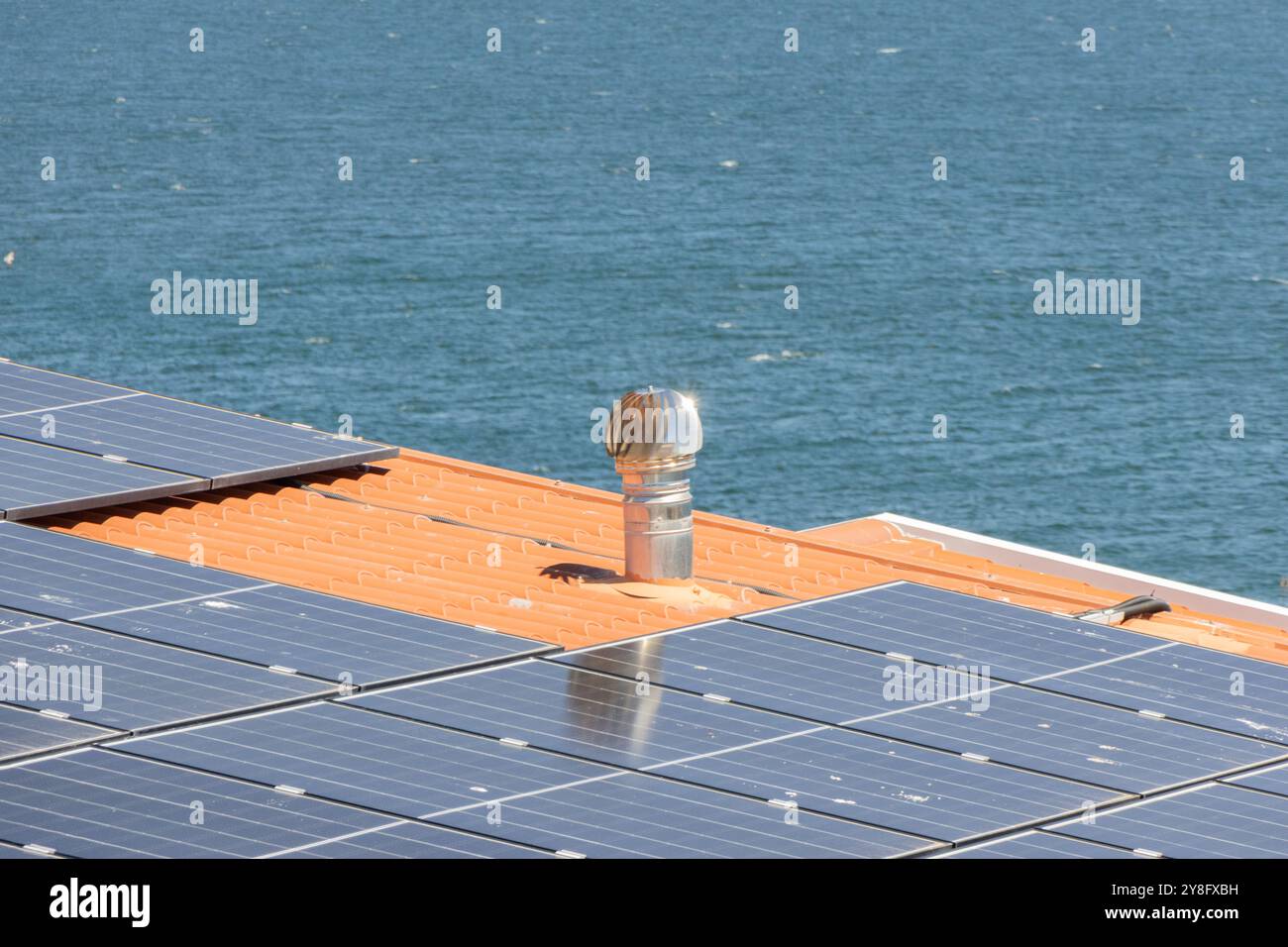 Metal chimney with a turbine ventilator is installed on a roof with ...