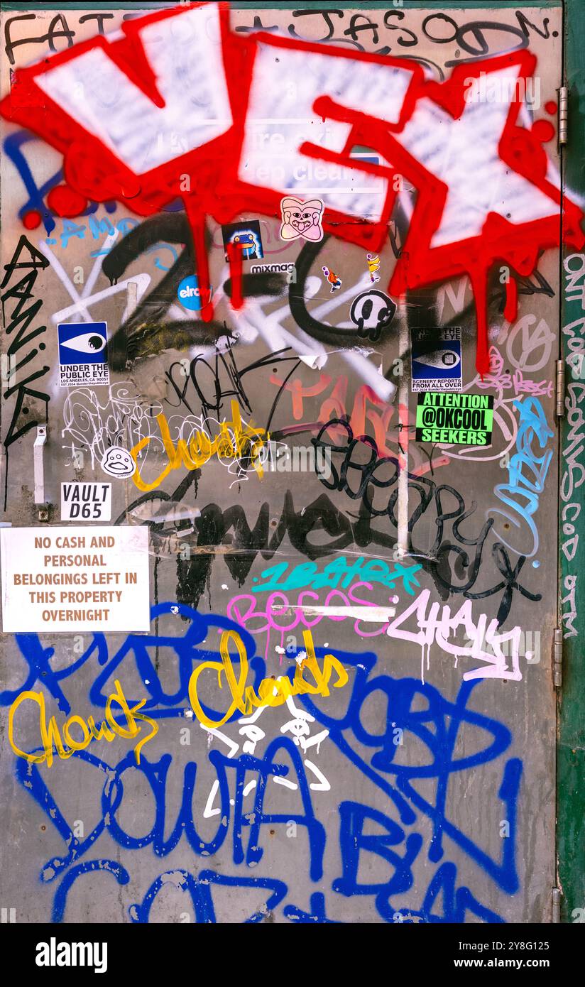 Colorful graffiti scrawled on a metal door creates a background with an ...