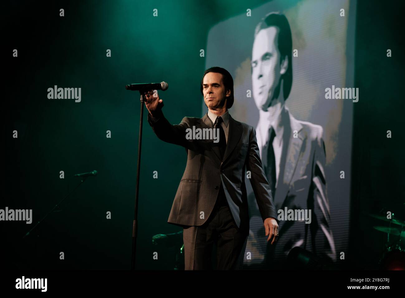 Nick Cave reaching out for the microphone as he enters the stage to ...