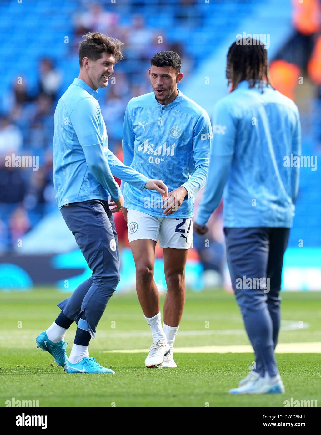 Manchester City's Matheus Nunes (centre) and John Stones (left) warming ...