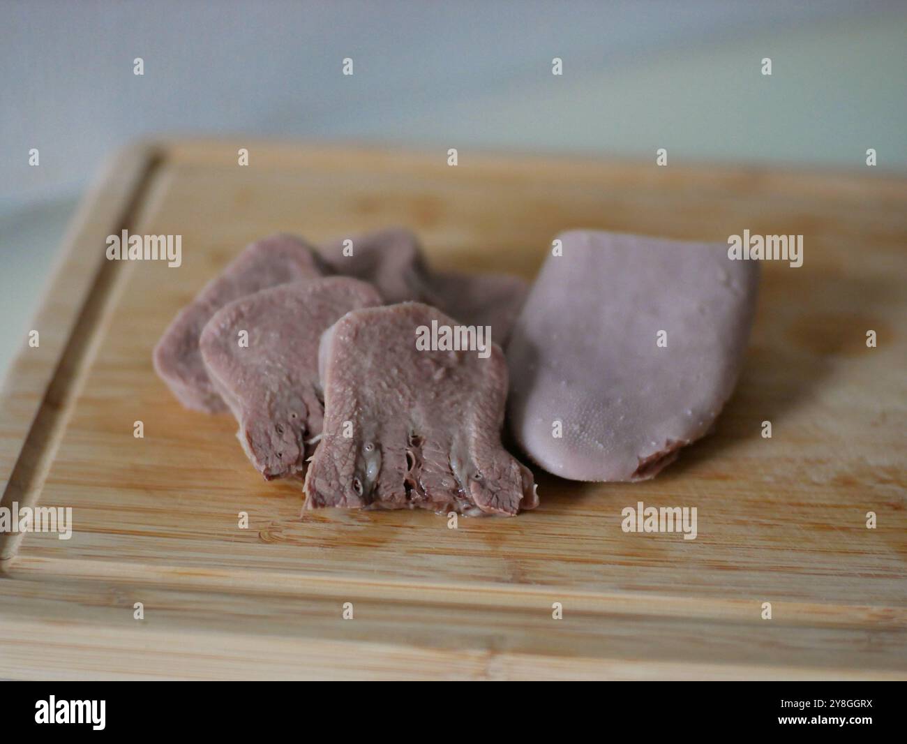 Cut boiled beef tongue on a wooden cutting board Stock Photo - Alamy