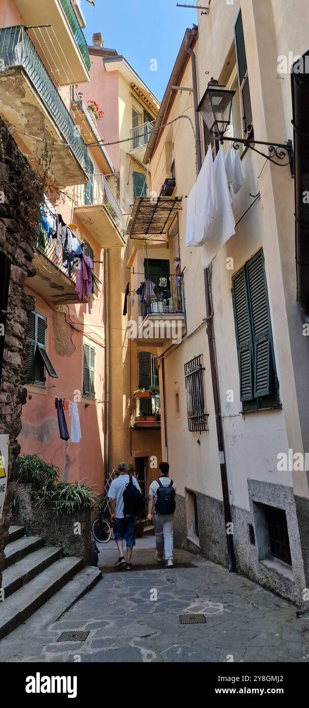 Tourists in a typical narrow italian street in the historic town of ...