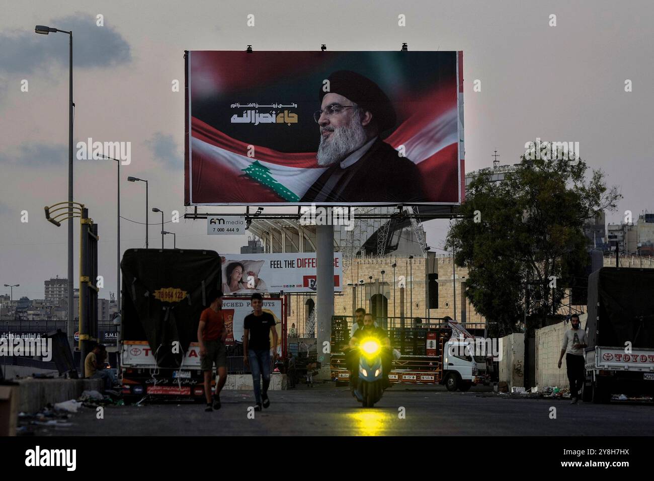 People walk past a billboard with a picture of the late Lebanon's ...