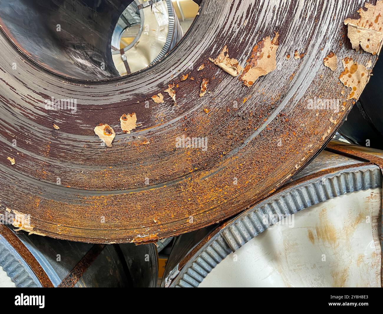 Rolls of rusty steel sheet inside the factory or warehouse. Problem on ...