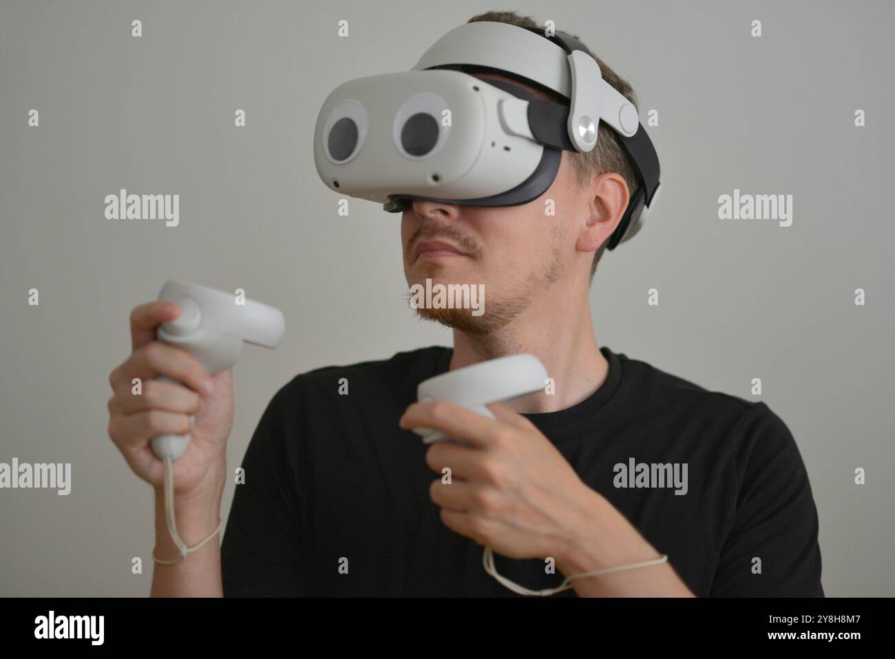 A Young Man Playing using Visual Reality Glasses with eye stickers. VR ...