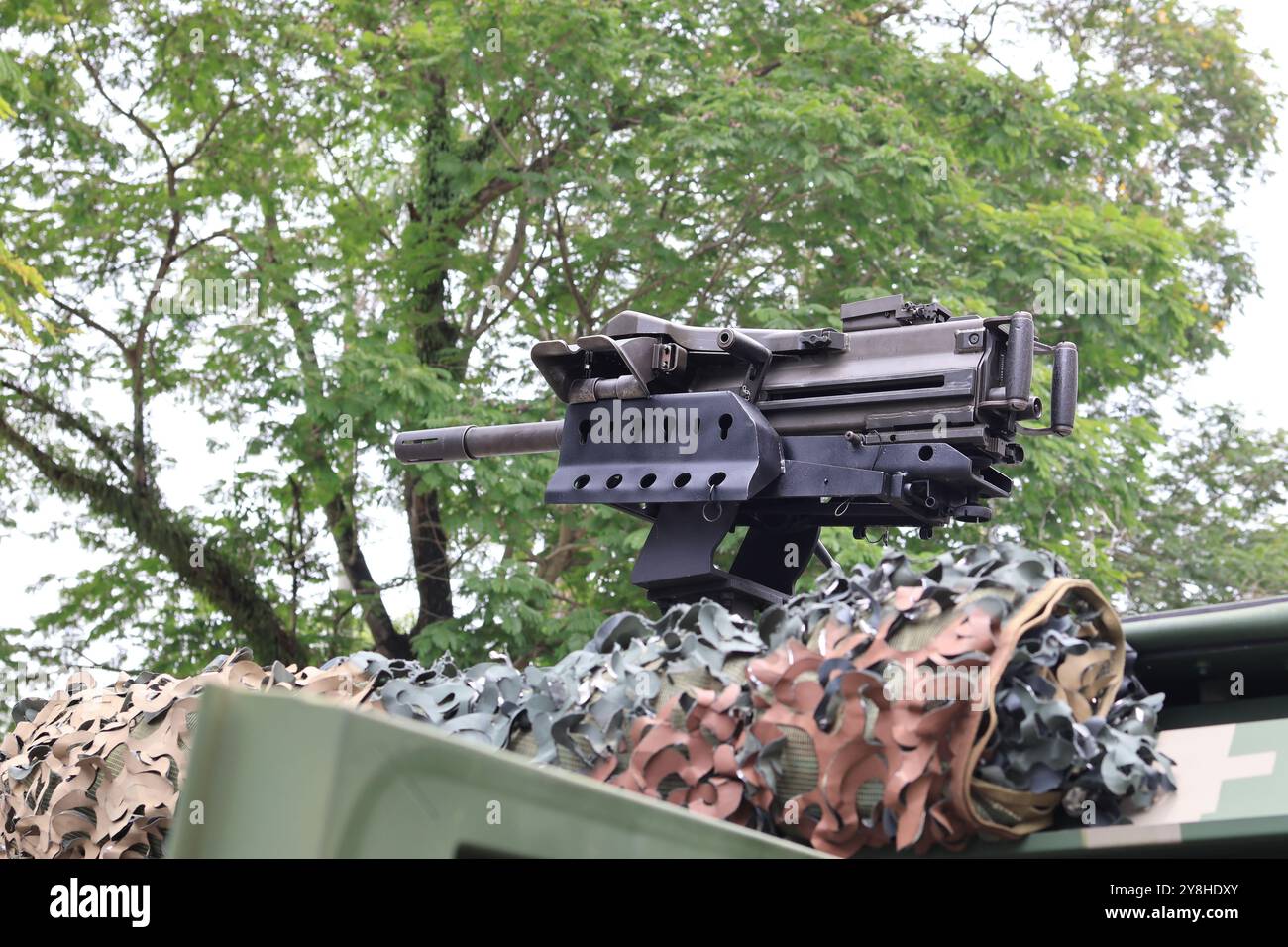 Close-up view of a automatic grenade launcher mounted on a camouflaged ...