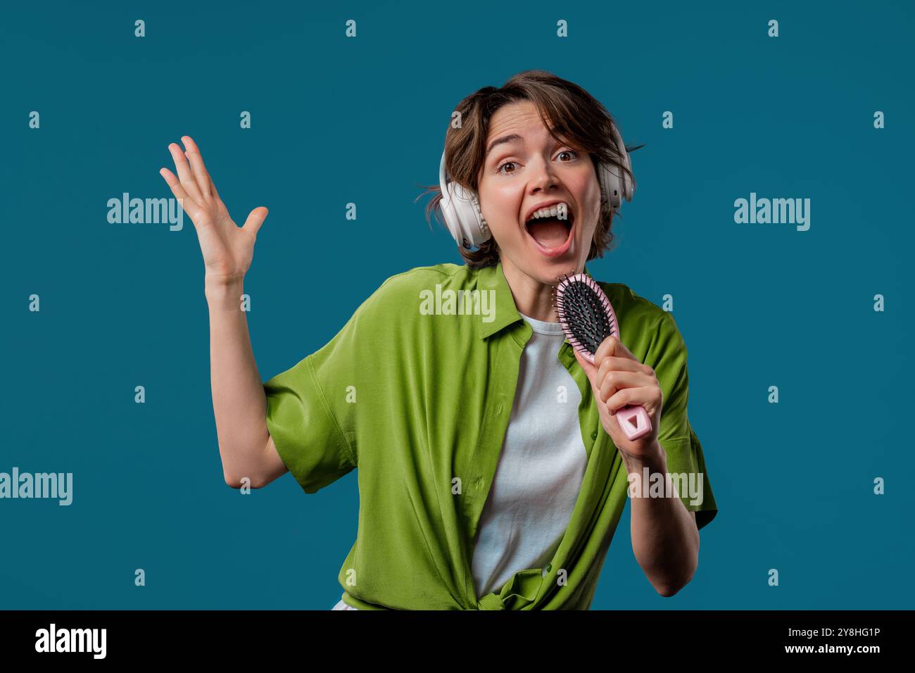 Woman singing, dancing with hair brush instead microphone on Blue ...