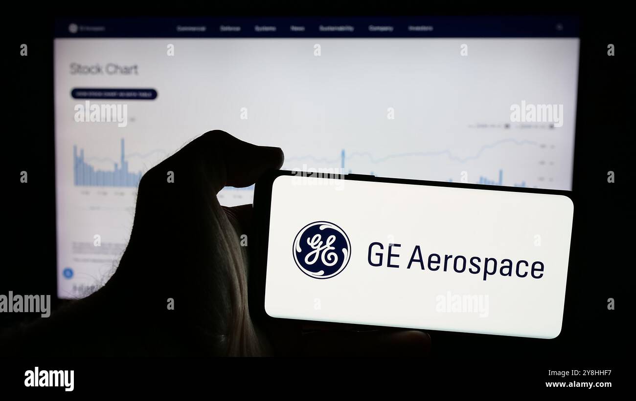 Person holding mobile phone with logo of American company GE Aerospace ...