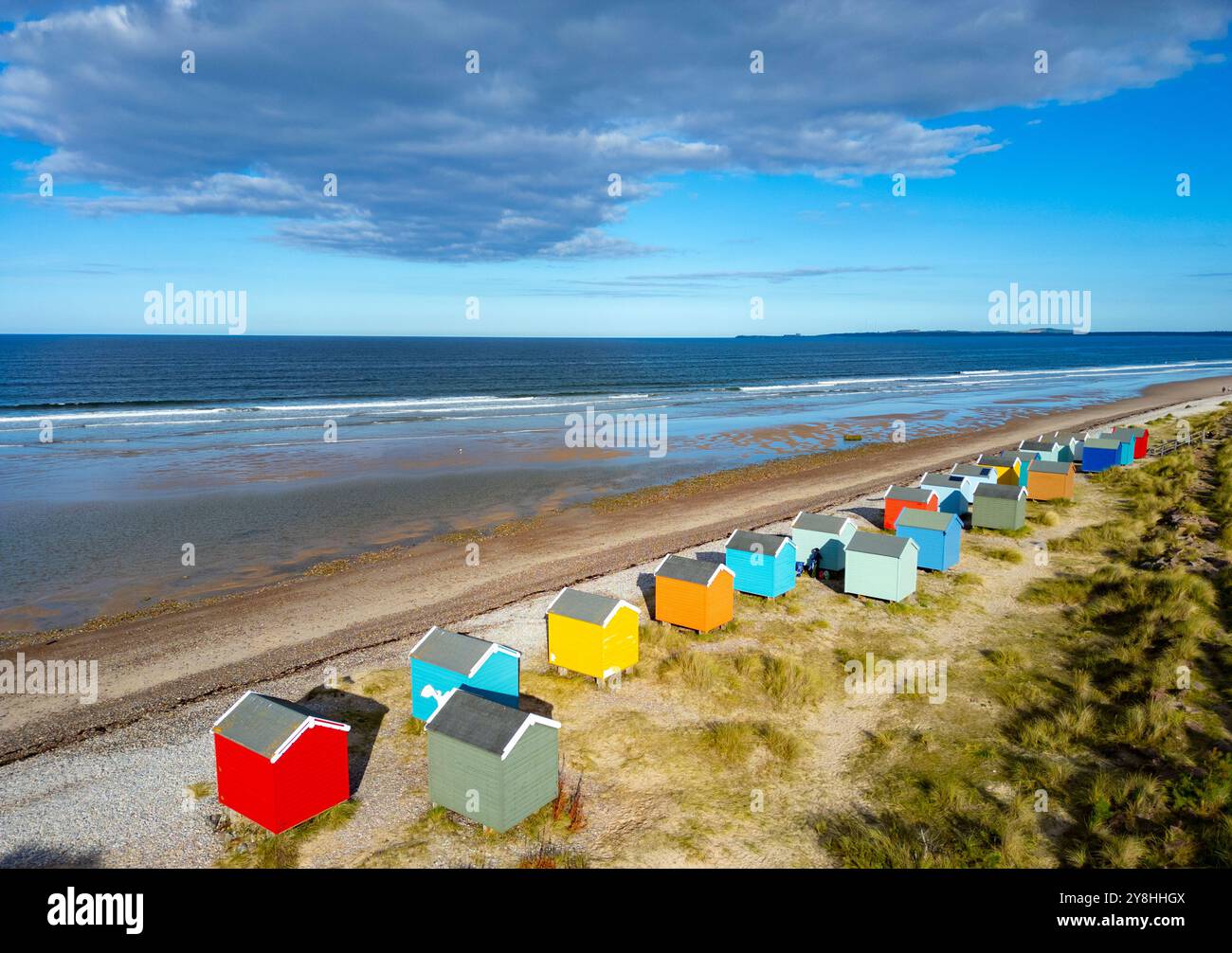 Aerial view from drone of colourful beach huts on beach at Findhorn on ...