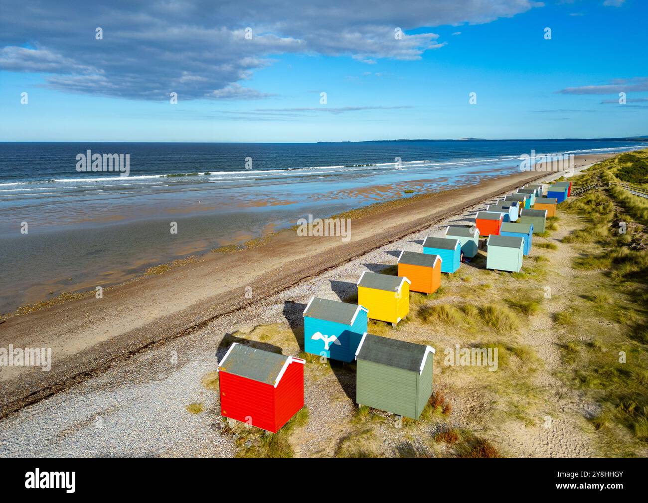 Aerial view from drone of colourful beach huts on beach at Findhorn on ...