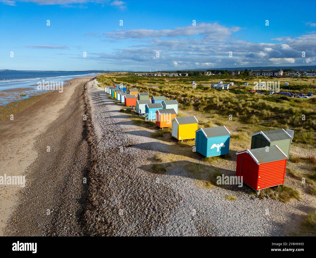Aerial view from drone of colourful beach huts on beach at Findhorn on ...
