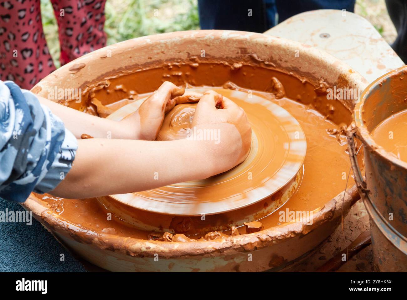 Pottery training. Rotating a clay pot on a machine. Hands knead clay ...