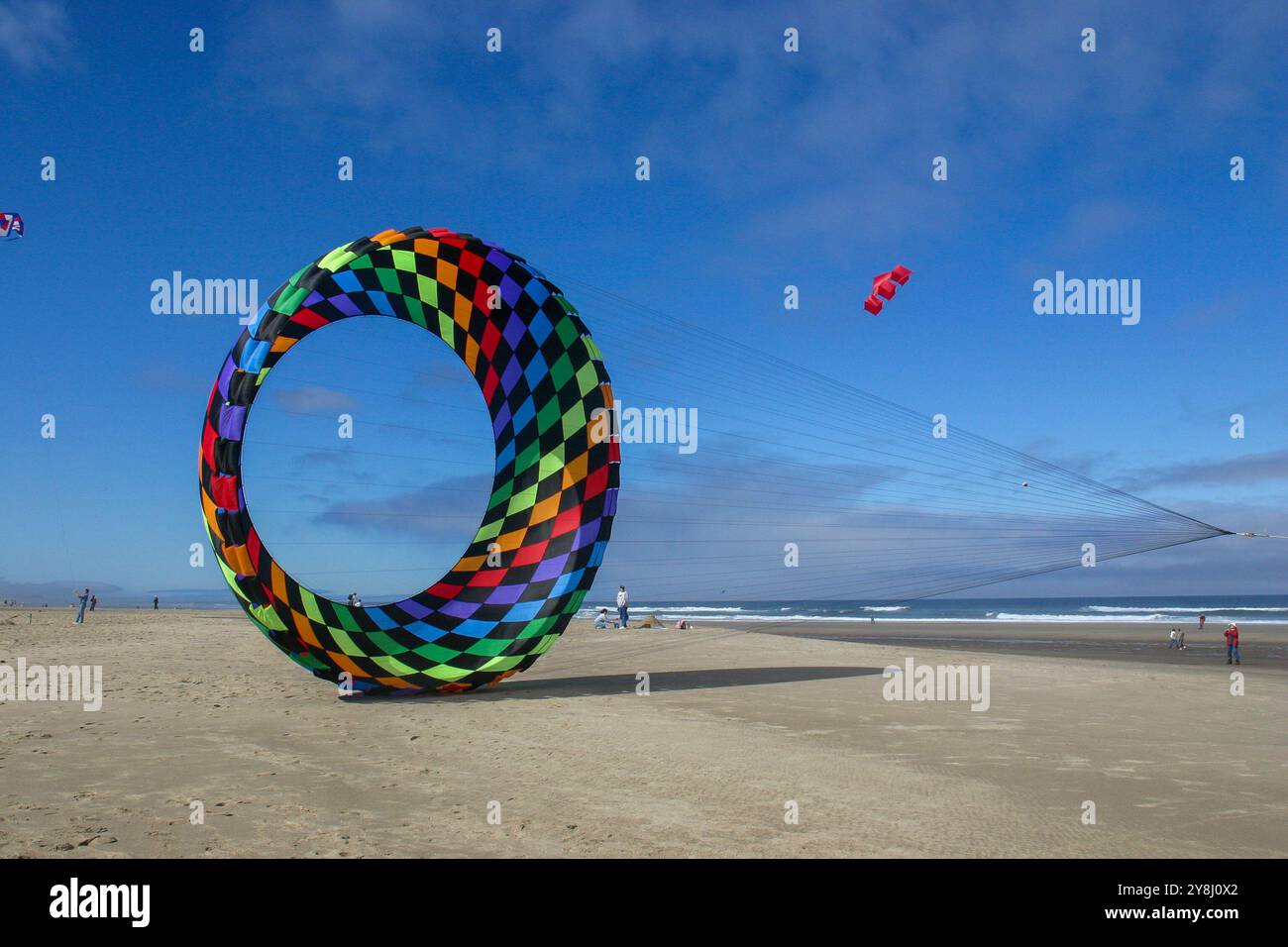 Large Circular Kite at a Beach Festival with Man Walking next to it on ...
