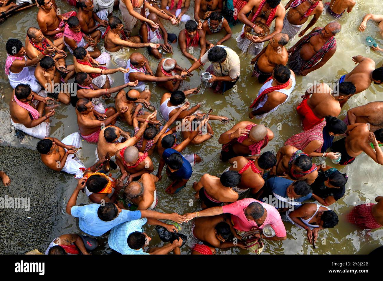 Hindu devotees offer their prayers to their ancestors as guided by the ...