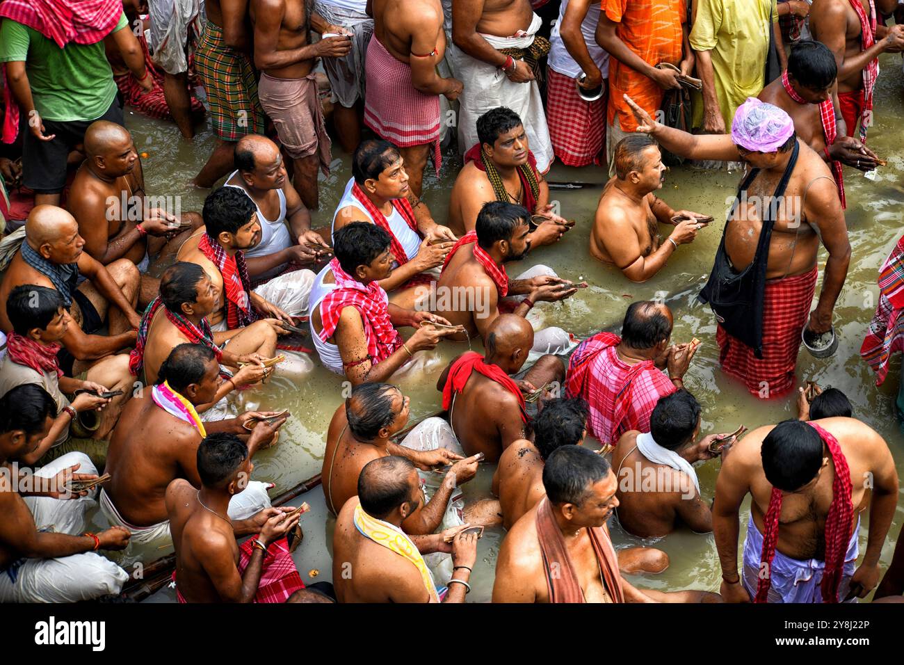 Hindu devotees offer their prayers to their ancestors as guided by the ...