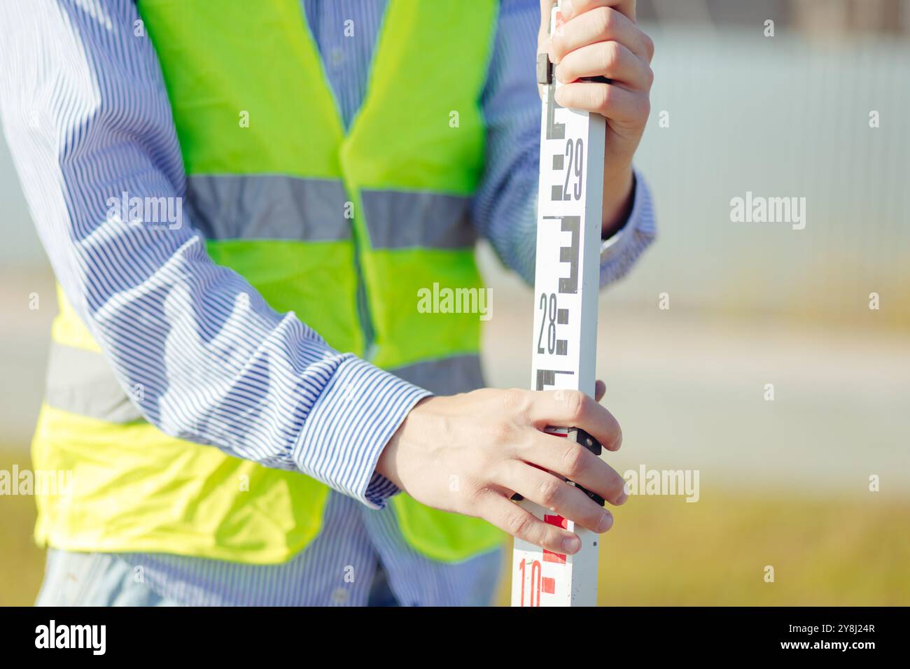 Worker is unfolding leveling rod on construction site Stock Photo - Alamy