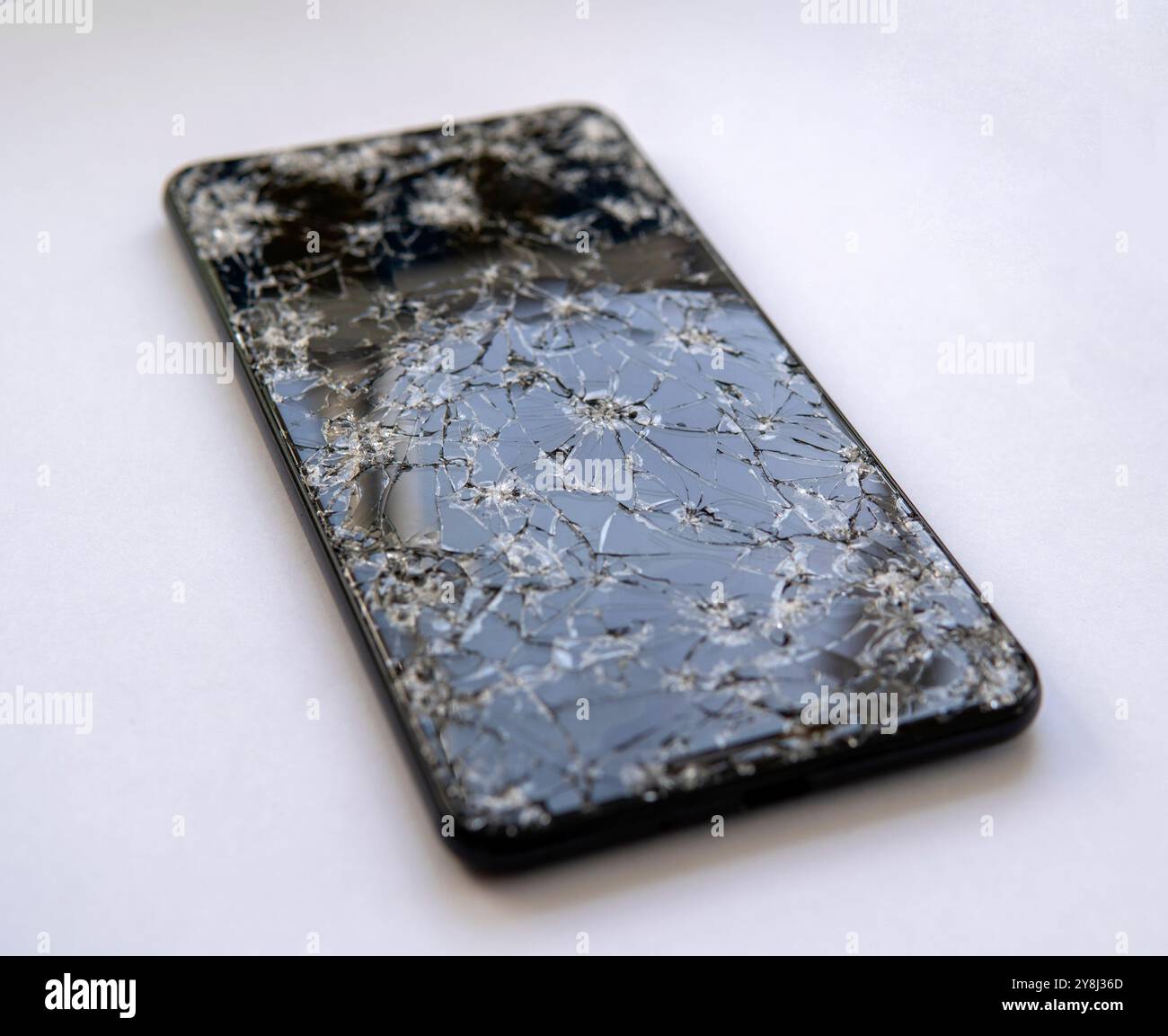 Smartphone with broken screen showing crack lines on the glass in close ...