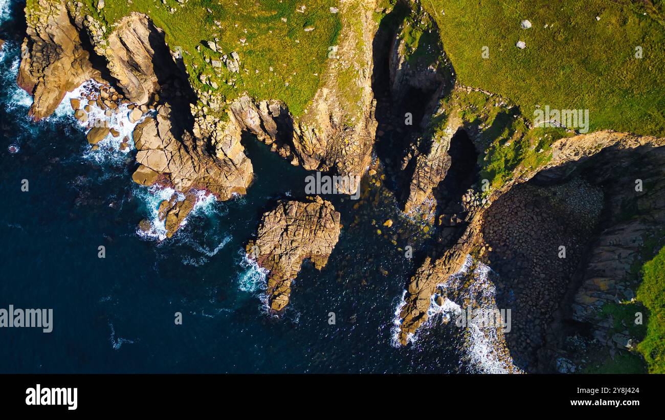 Aerial view of rugged coastal cliffs meeting the ocean. The landscape ...