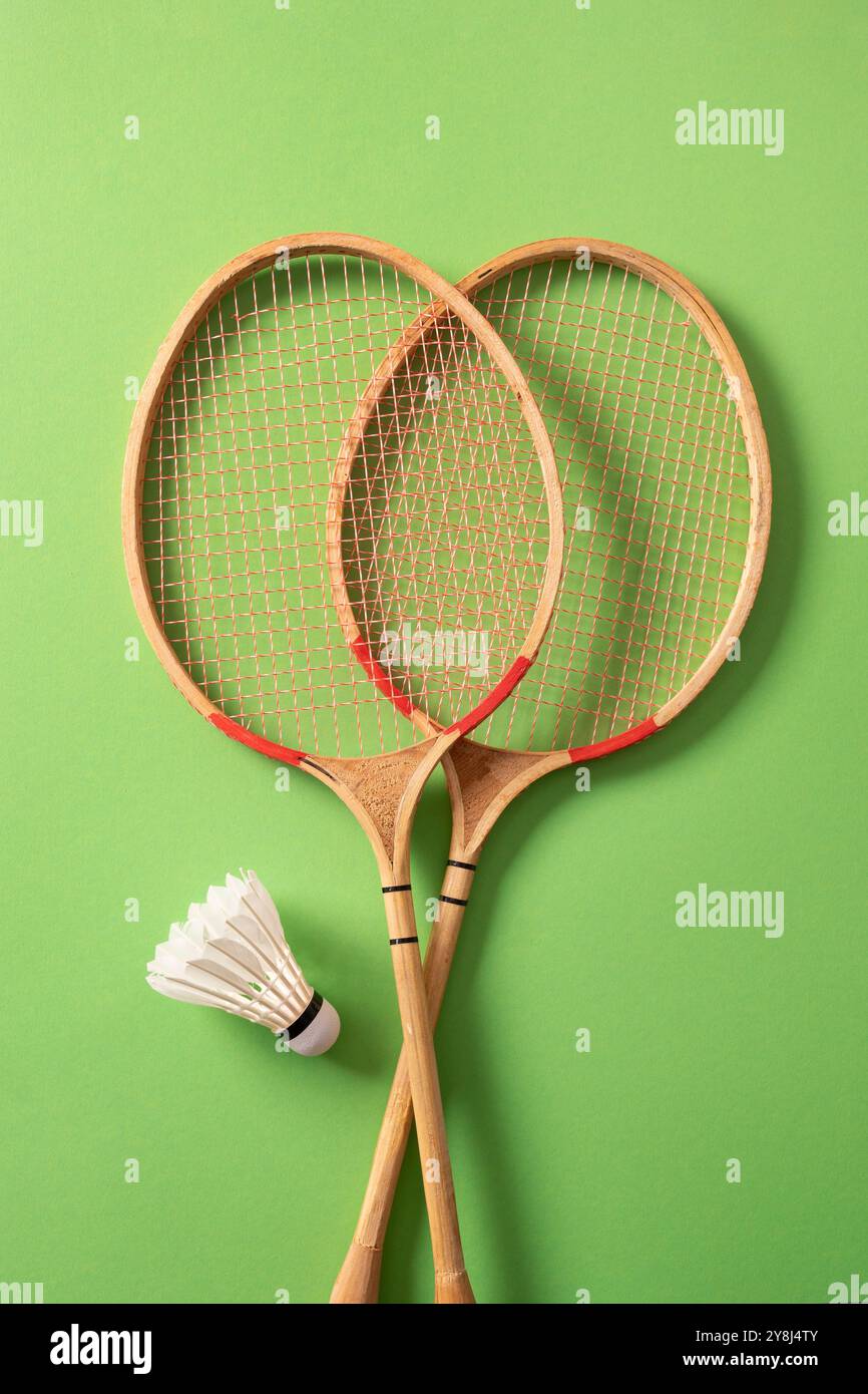 Two wooden badminton rackets and white feather badminton shuttlecock on ...