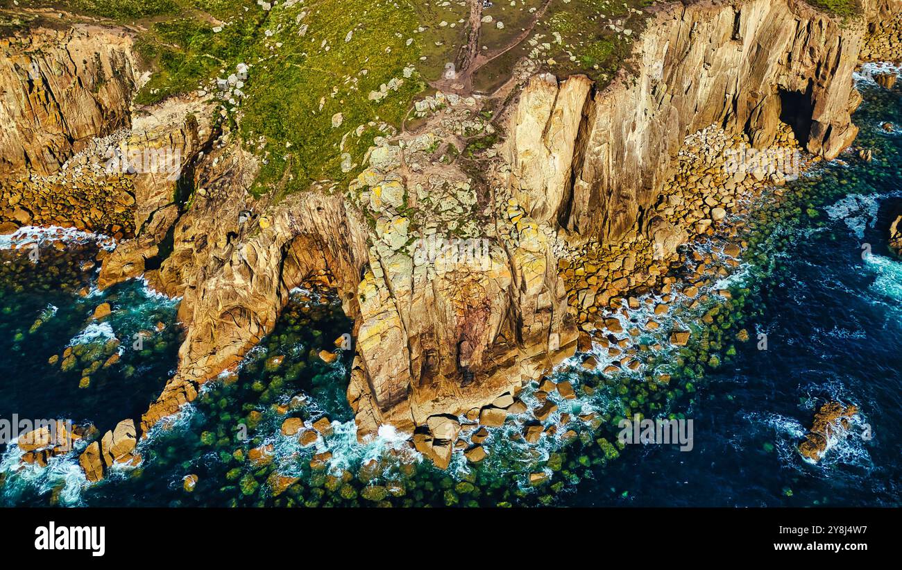 Aerial view of rugged coastal cliffs with green vegetation and rocky ...
