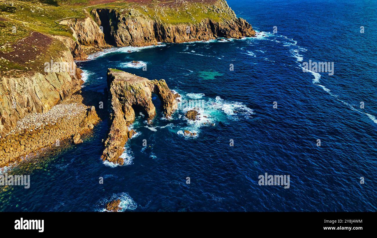 Aerial view of rugged coastal cliffs with a rock formation jutting into ...