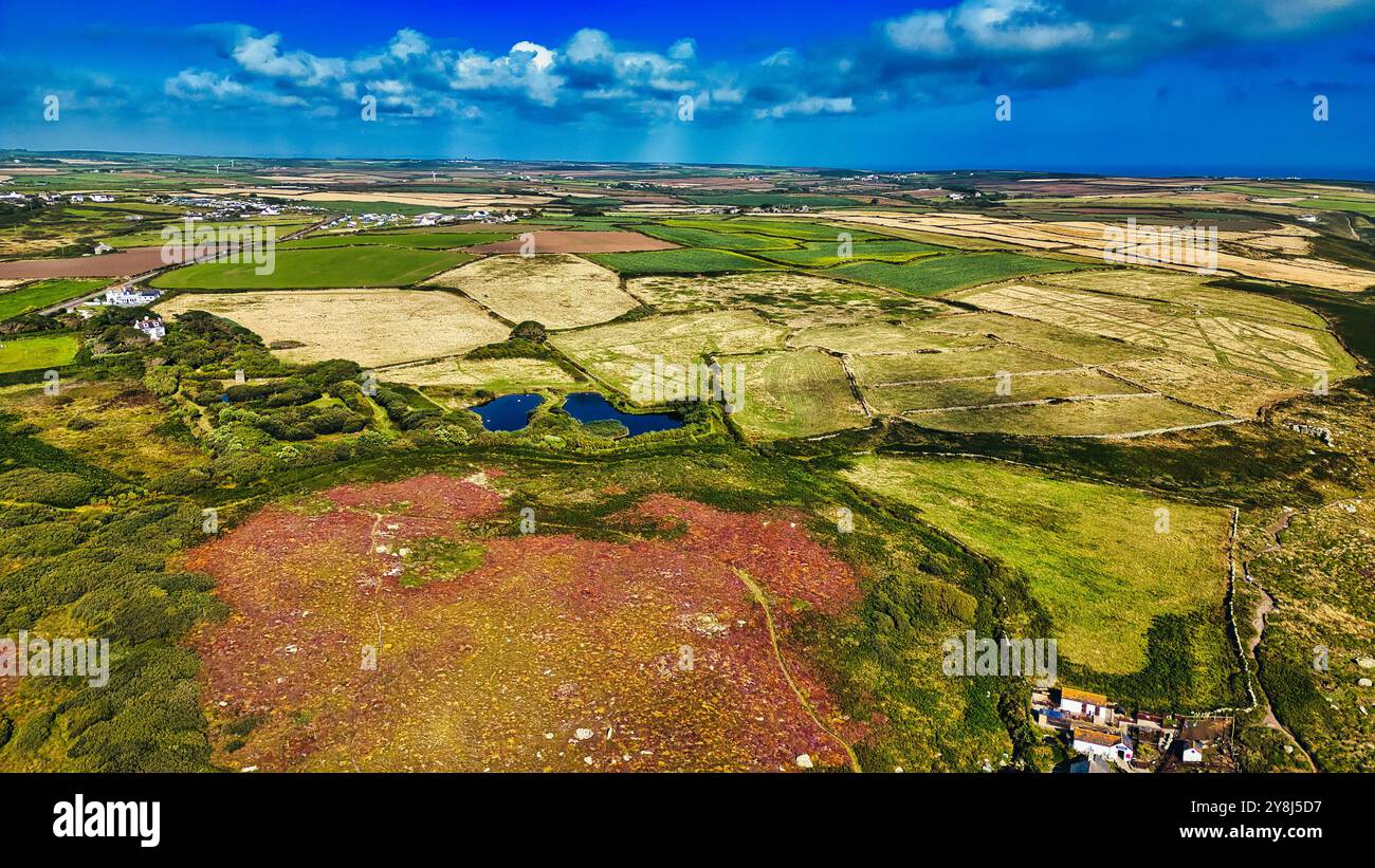 Aerial view of lush green fields and farmland under a bright blue sky ...