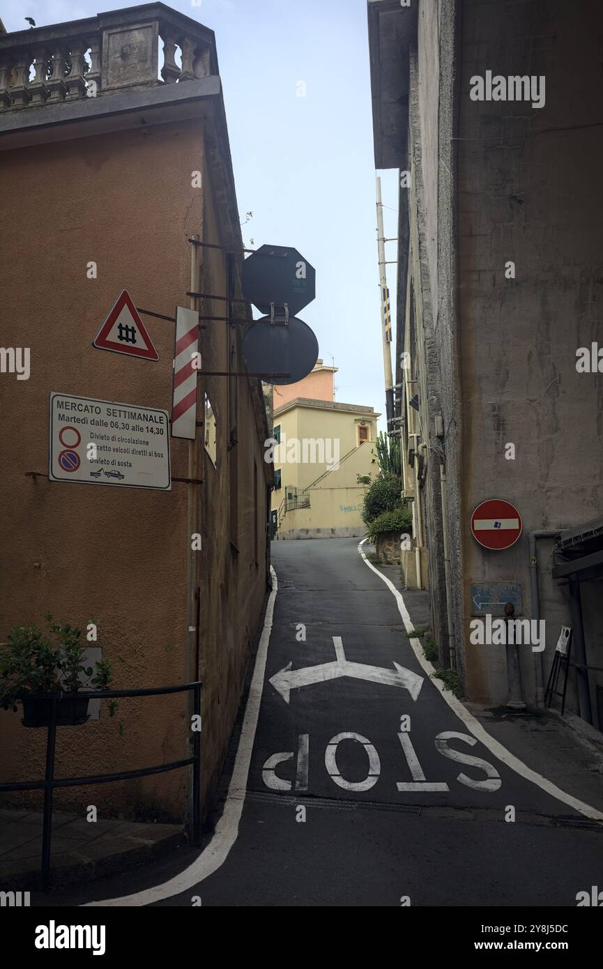 Narrow alley on a slope next to a bridge with a stop sign on the ground ...