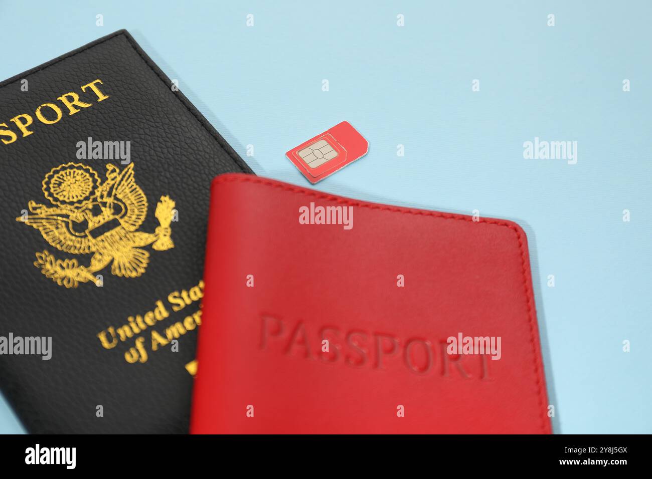 Modern SIM card and passport on light blue background, closeup Stock ...