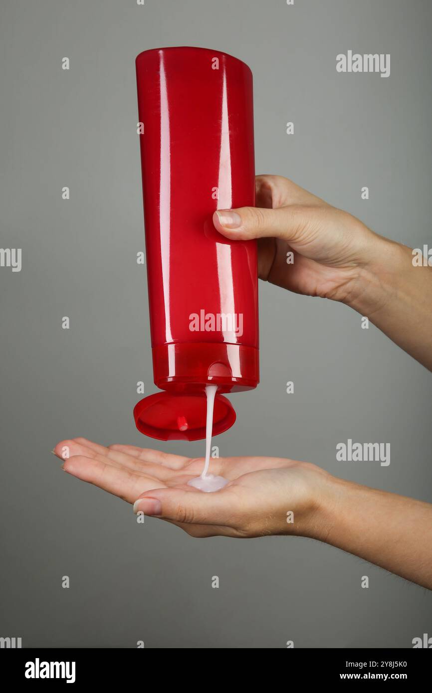 Woman pouring shampoo onto hand on grey background, closeup Stock Photo ...