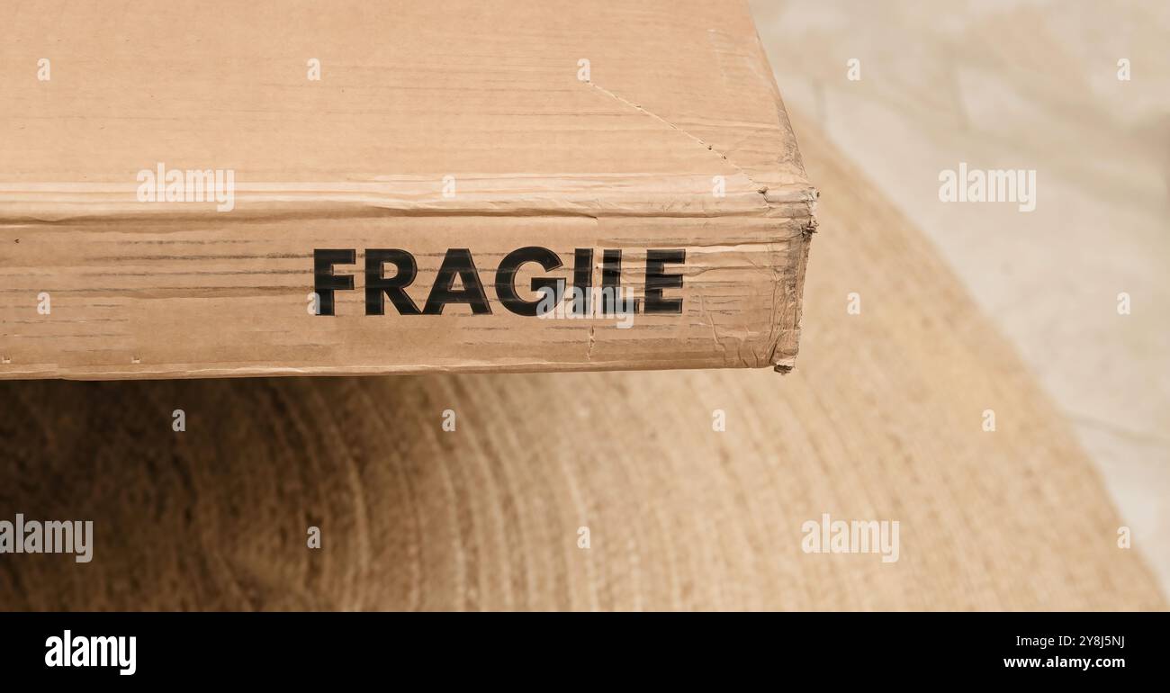 A close-up view of a cardboard box corner with the word Fragile printed ...