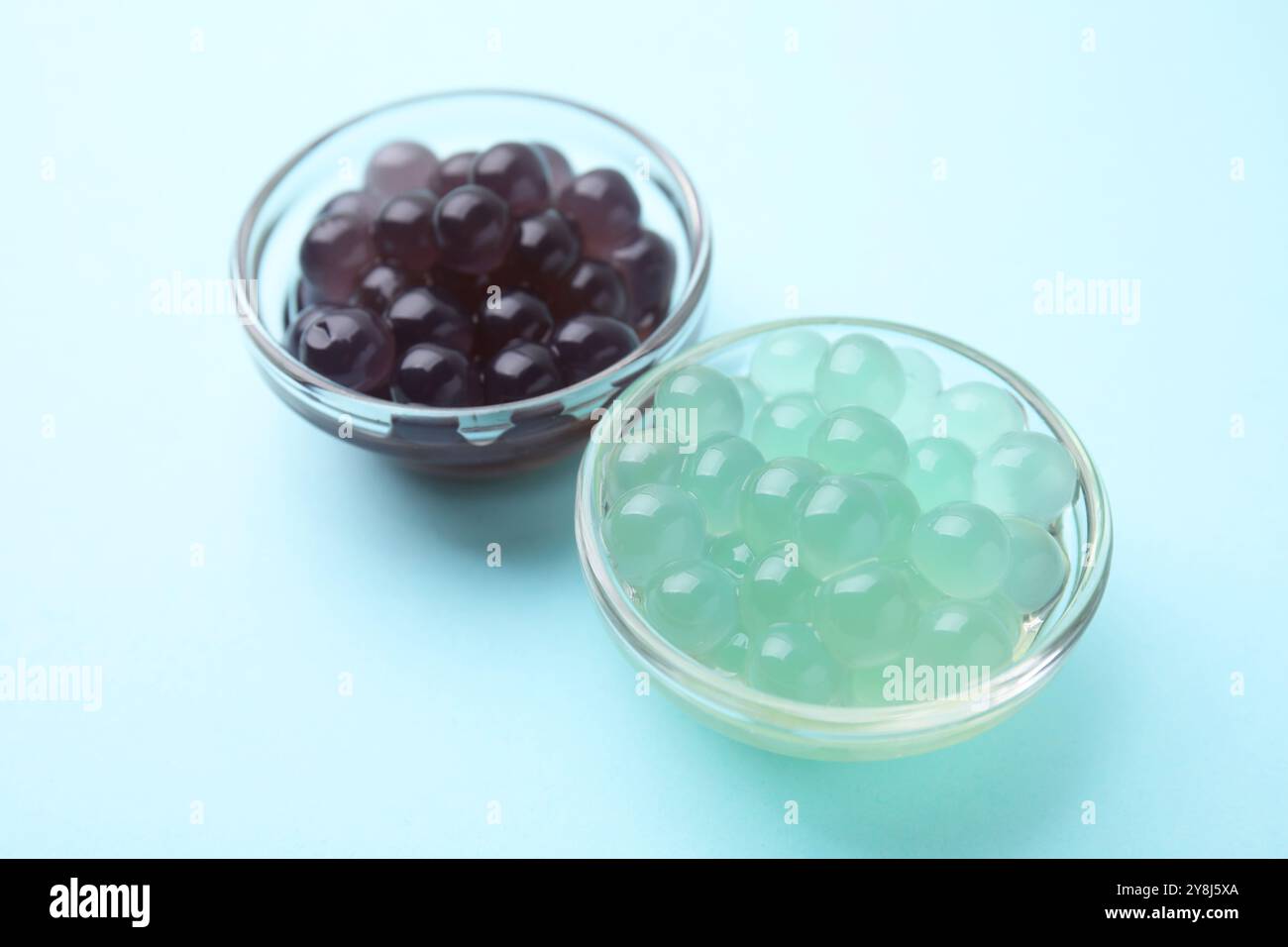 Color tapioca pearls in bowls on light blue background, closeup Stock ...