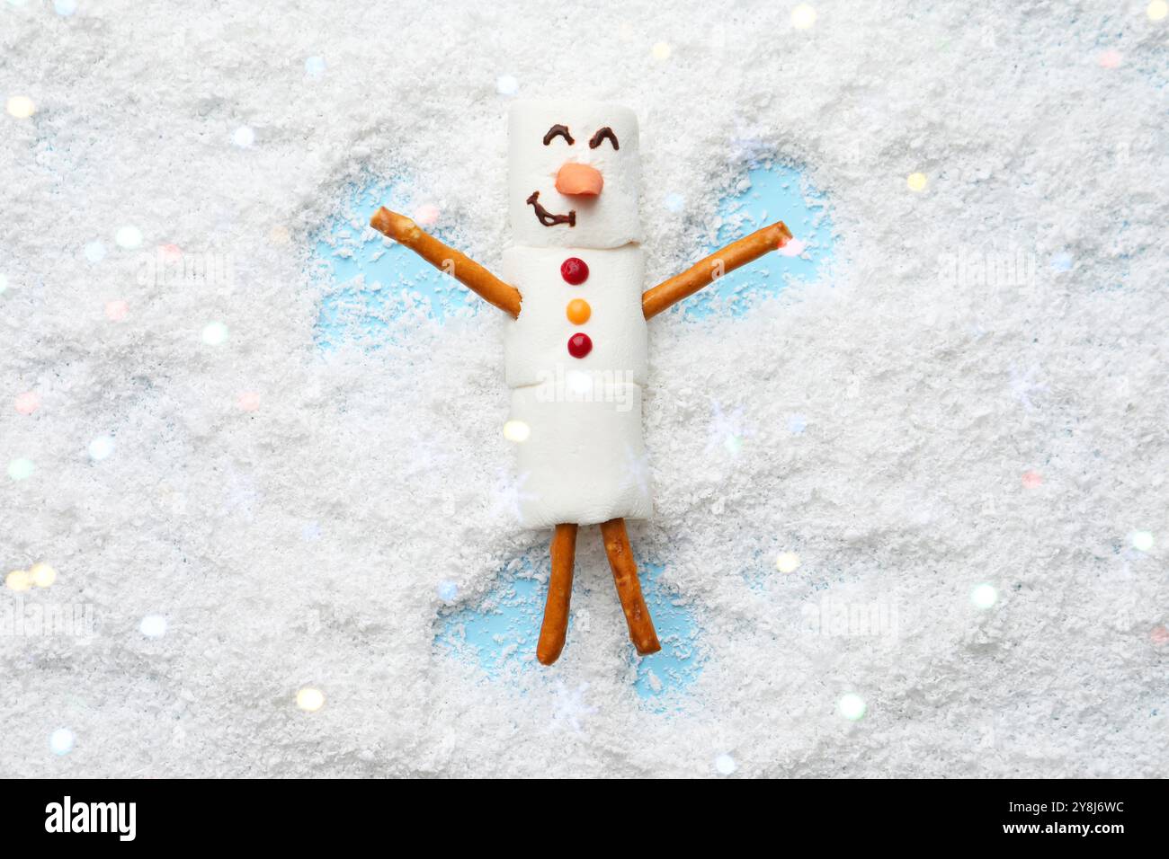 Marshmallow snowman making angel on artificial snow, top view Stock ...