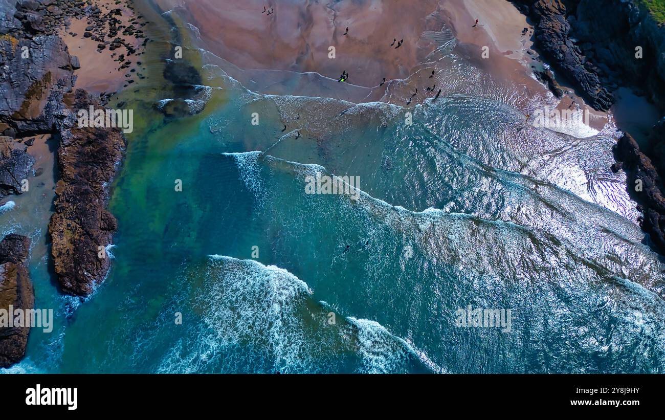 Aerial view of a beach with clear blue waters and sandy shores. Waves ...