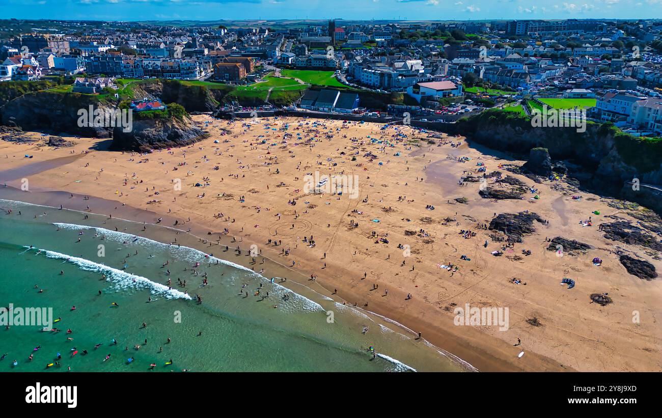 Aerial view of a sandy beach filled with sunbathers and surfers, with a ...