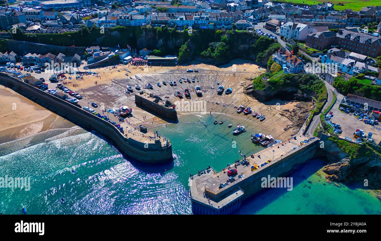 Aerial view of a coastal harbor with boats and sandy beach. The harbor ...
