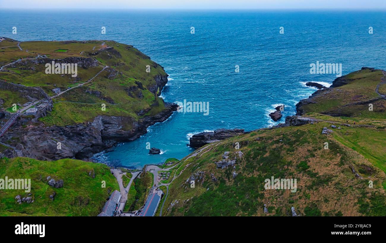 Aerial view of a coastal landscape featuring rugged cliffs, lush green ...
