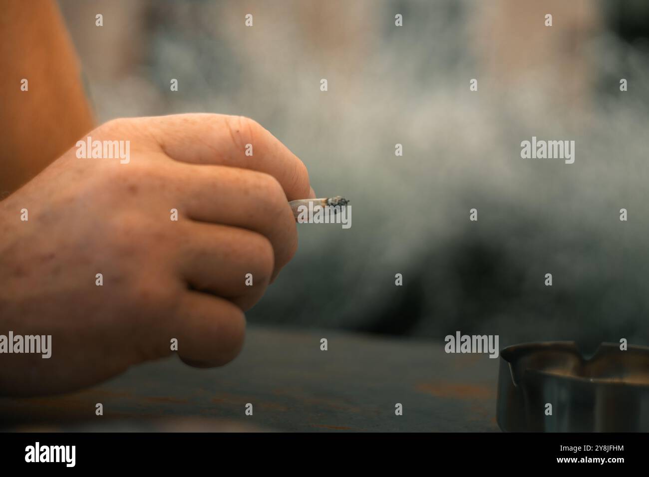 Cigarette in hand, smoking tobacco Stock Photo - Alamy