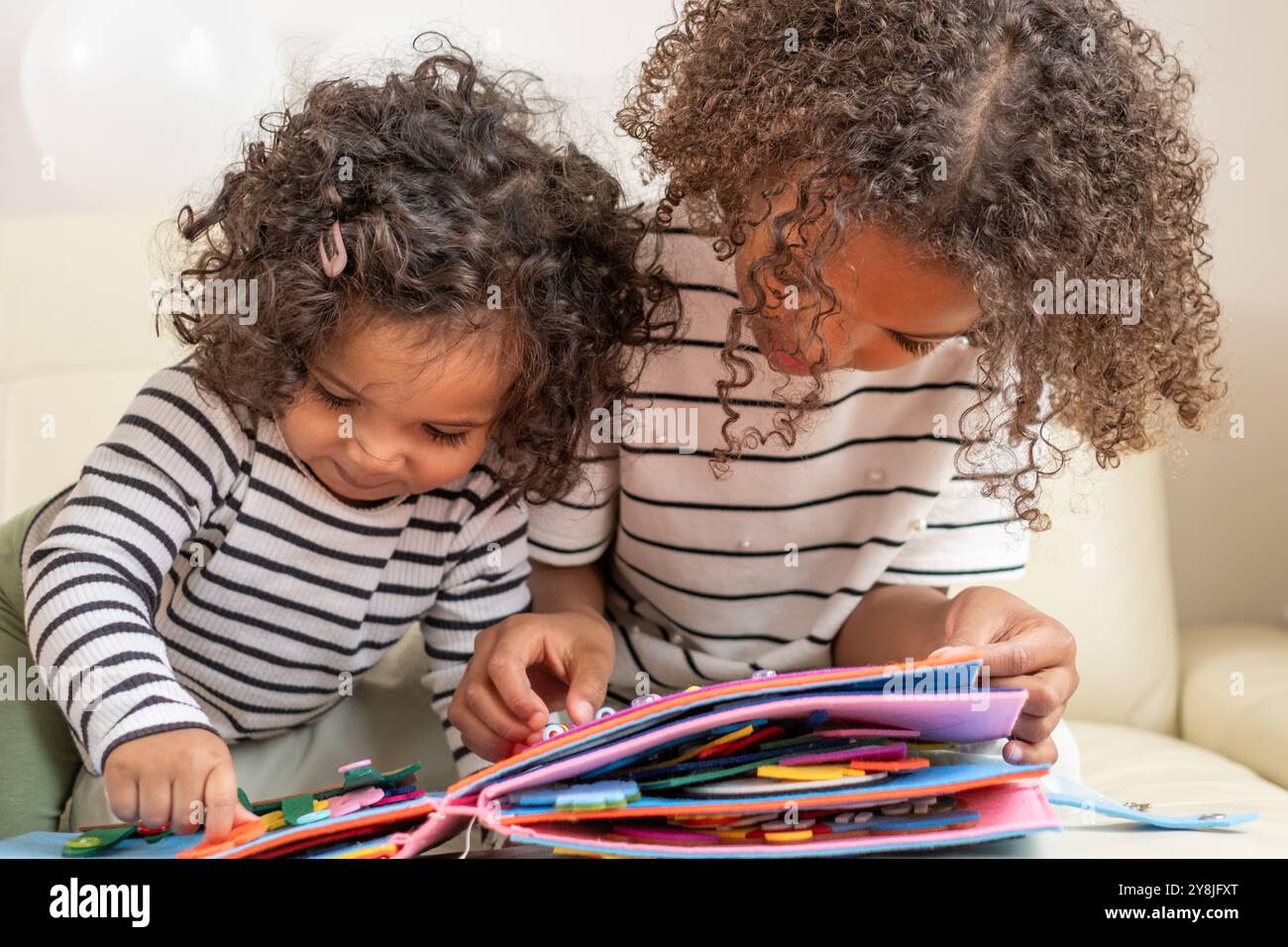 Siblings joyfully read a colorful book together, exploring stories ...