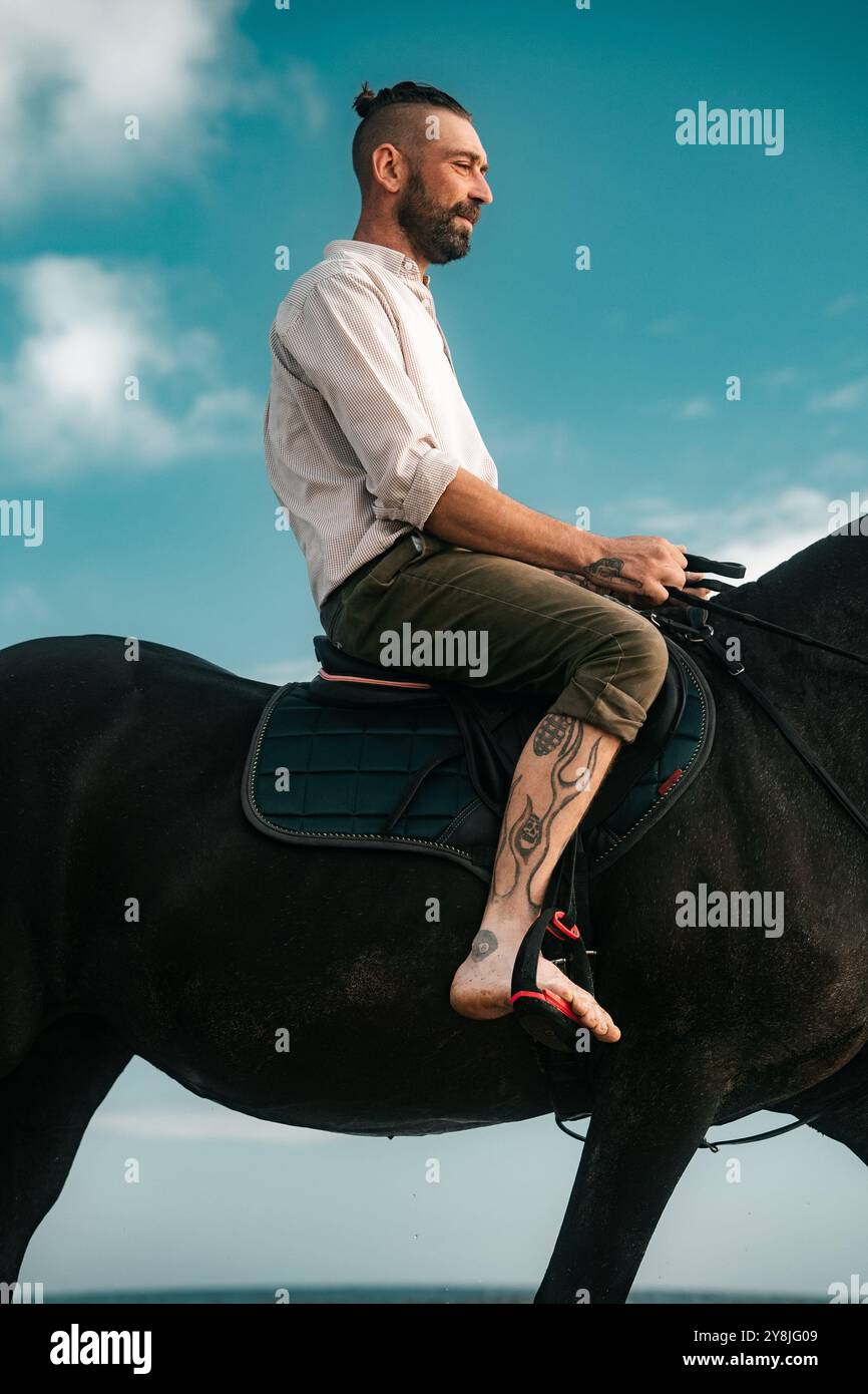 Man with tattoos riding a horse Stock Photo - Alamy