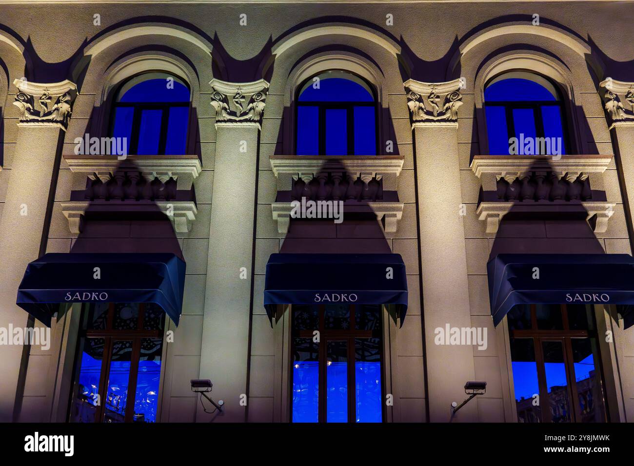 An ornate building facade with illuminated windows is captured at night ...